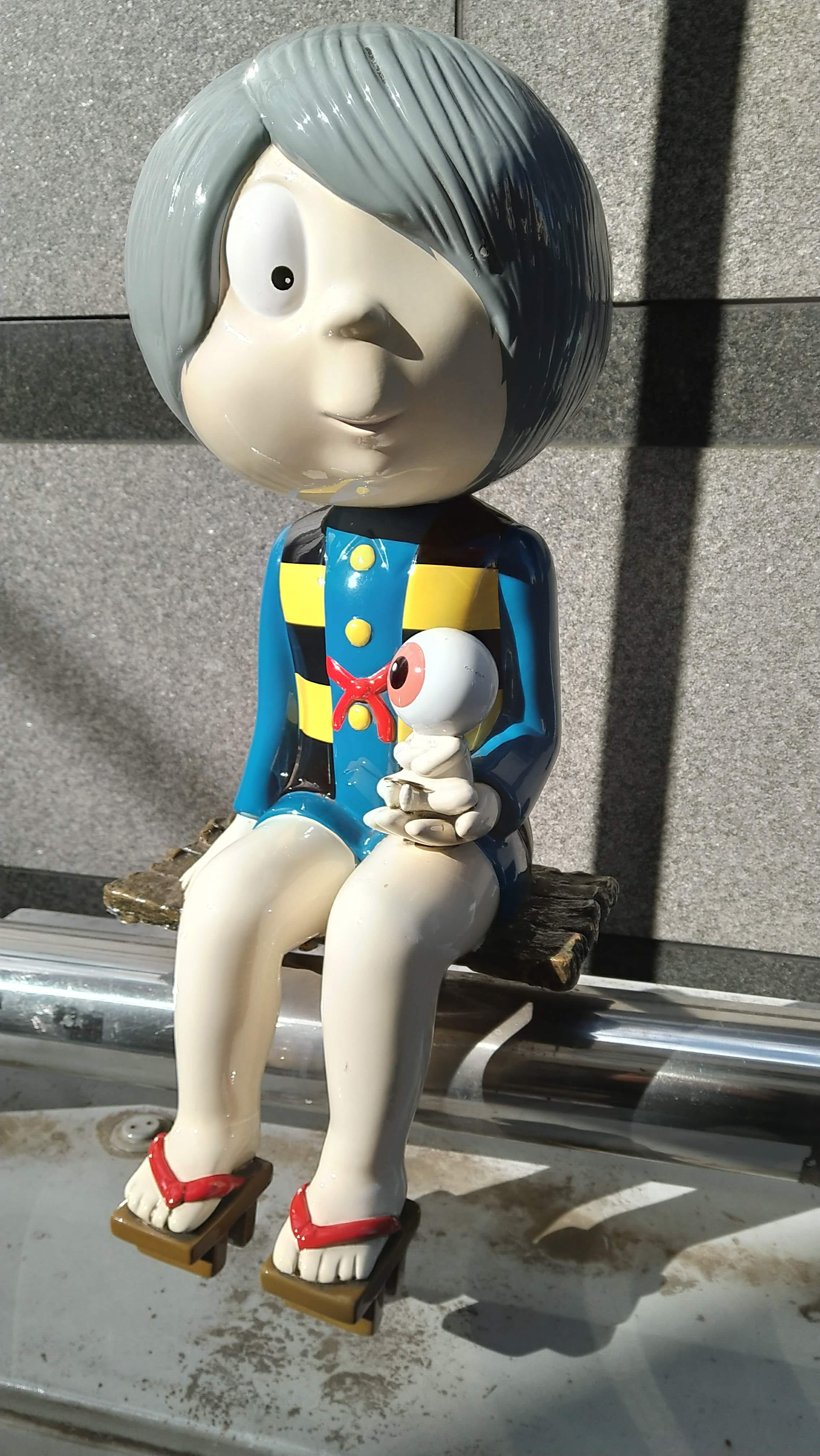 A specter from "GeGeGe no Kitaro" anime is sitting in an alley, in ...